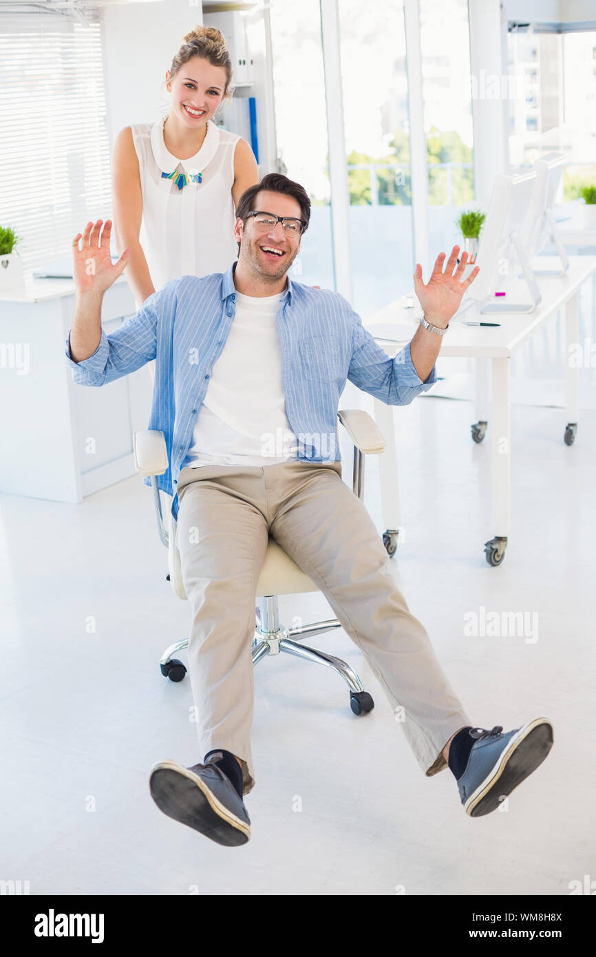 Man on swivel chair with hands up in office Stock Photo - Alamy