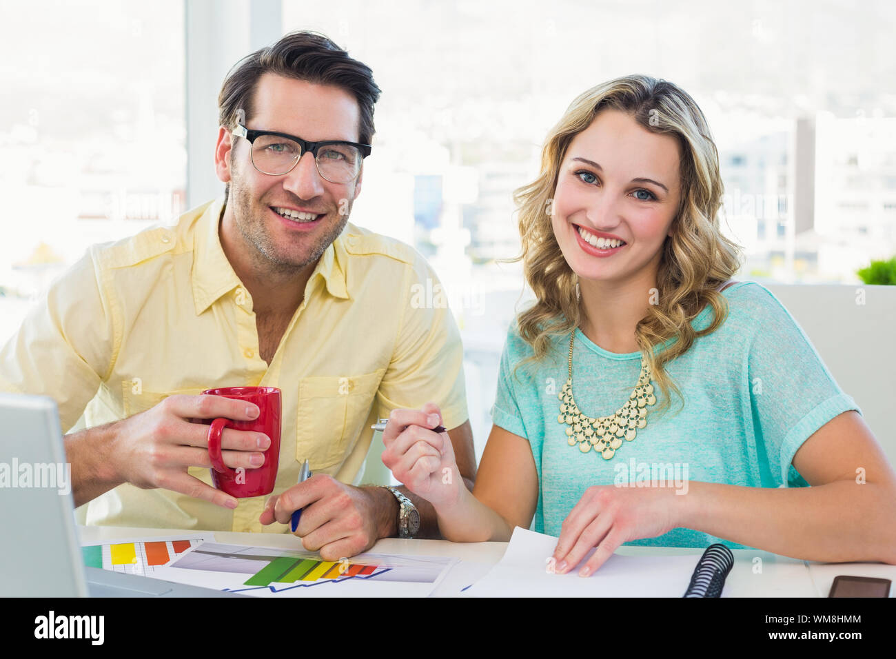 Interior designer drinking coffee at desk in office Stock Photo - Alamy