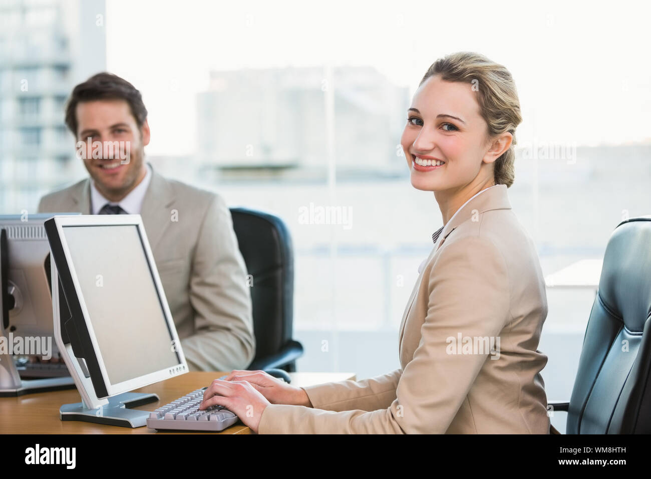 Two young business people using computer in office Stock Photo - Alamy