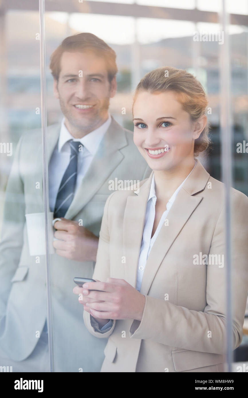 Business people looking at camera through the window at work Stock ...
