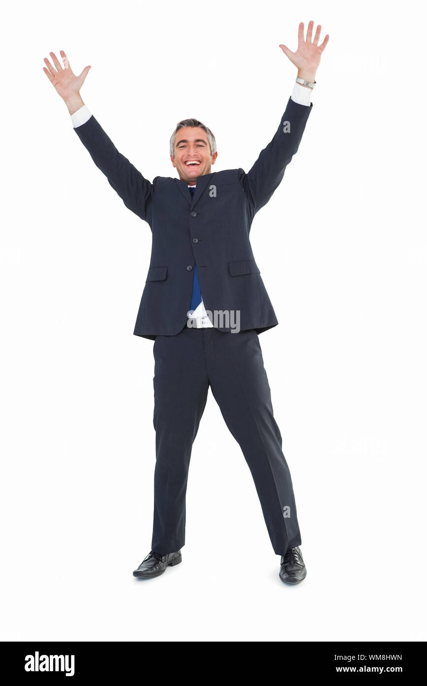 Happy businessman in suit with arms up on white background Stock Photo ...