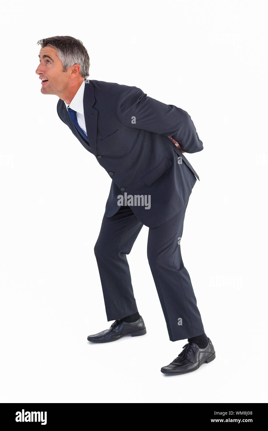 Businessman bending with arms on his back on white background Stock ...
