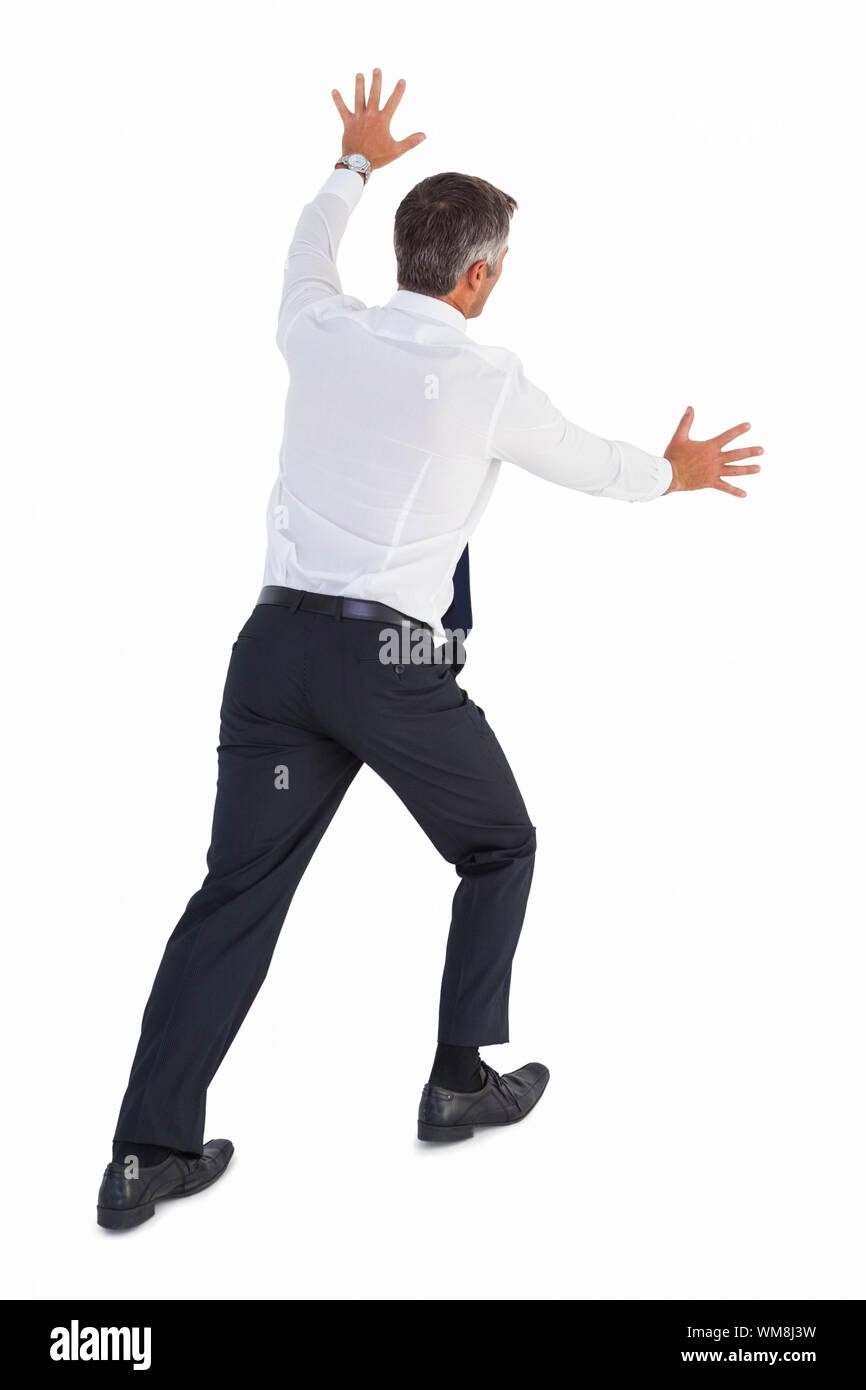 Businessman standing and pushing a wall on white background Stock Photo ...
