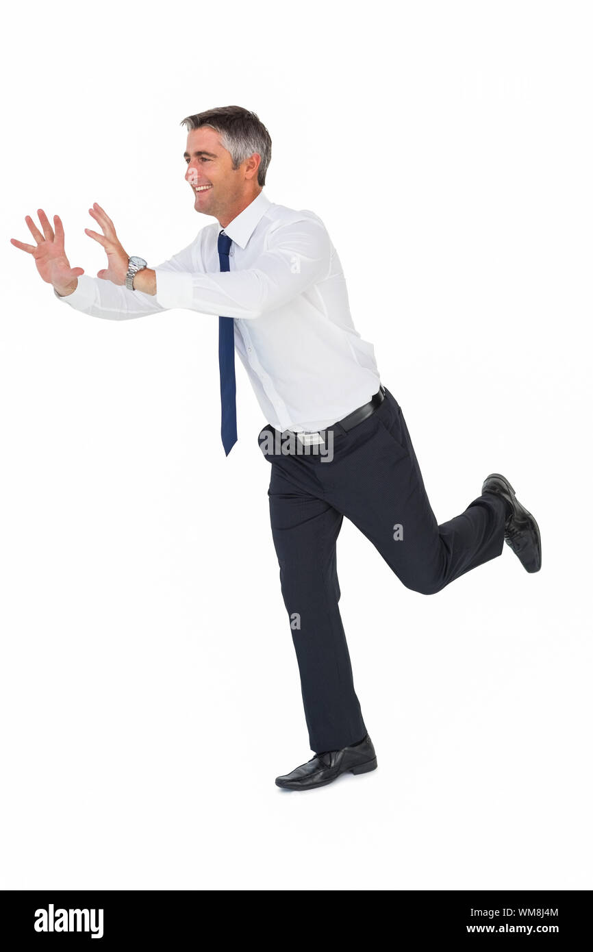 Happy businessman without jacket catching something on white background ...