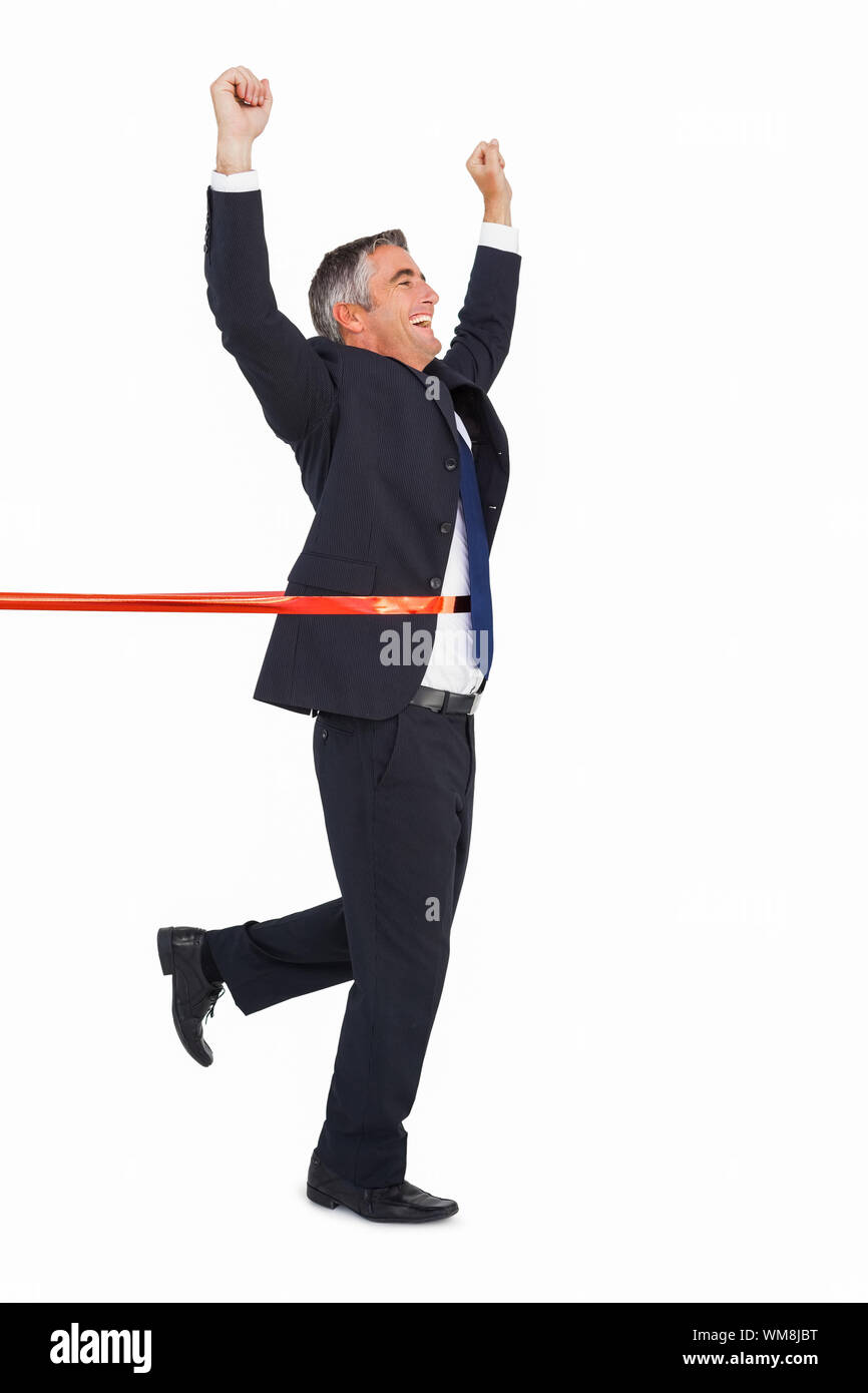 Happy businessman crossing finishing line on white background Stock ...