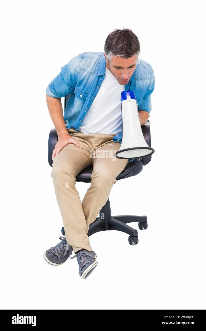 Man sitting on a office chair speaking on megaphone on white background ...