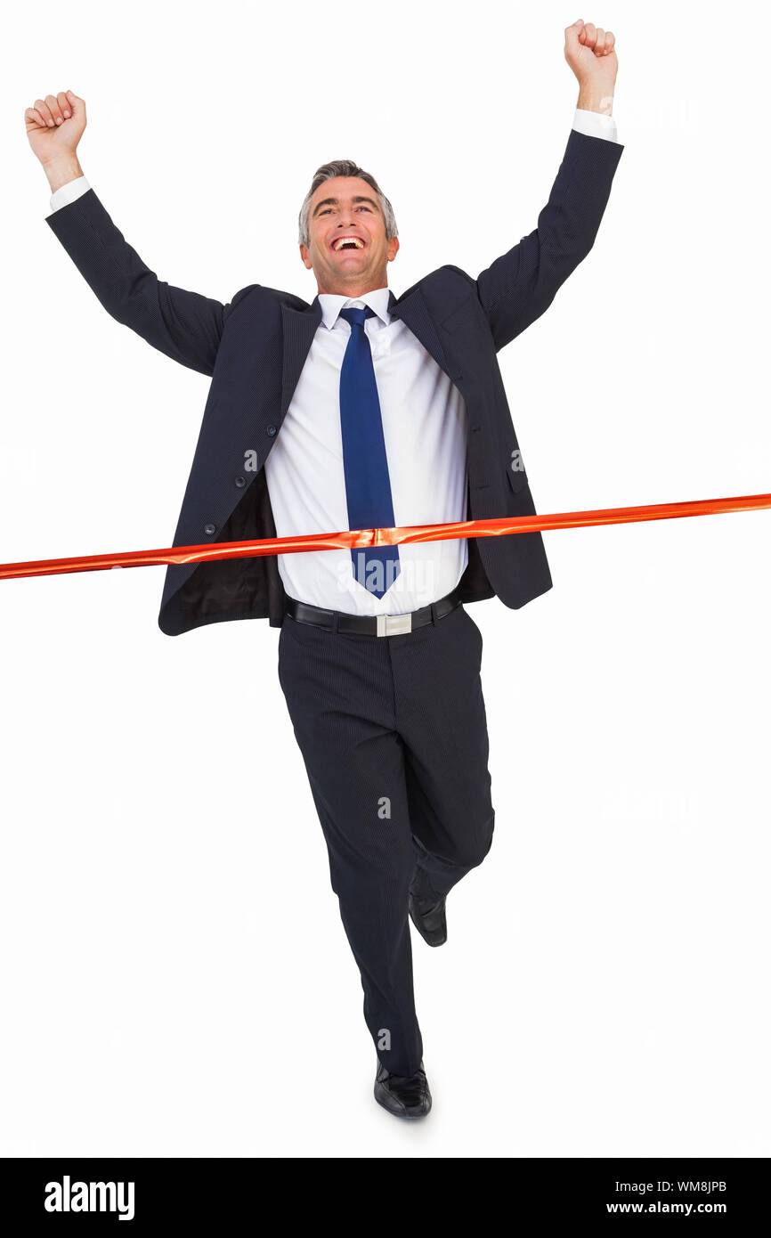 Businessman crossing finish line and cheering on white background Stock ...