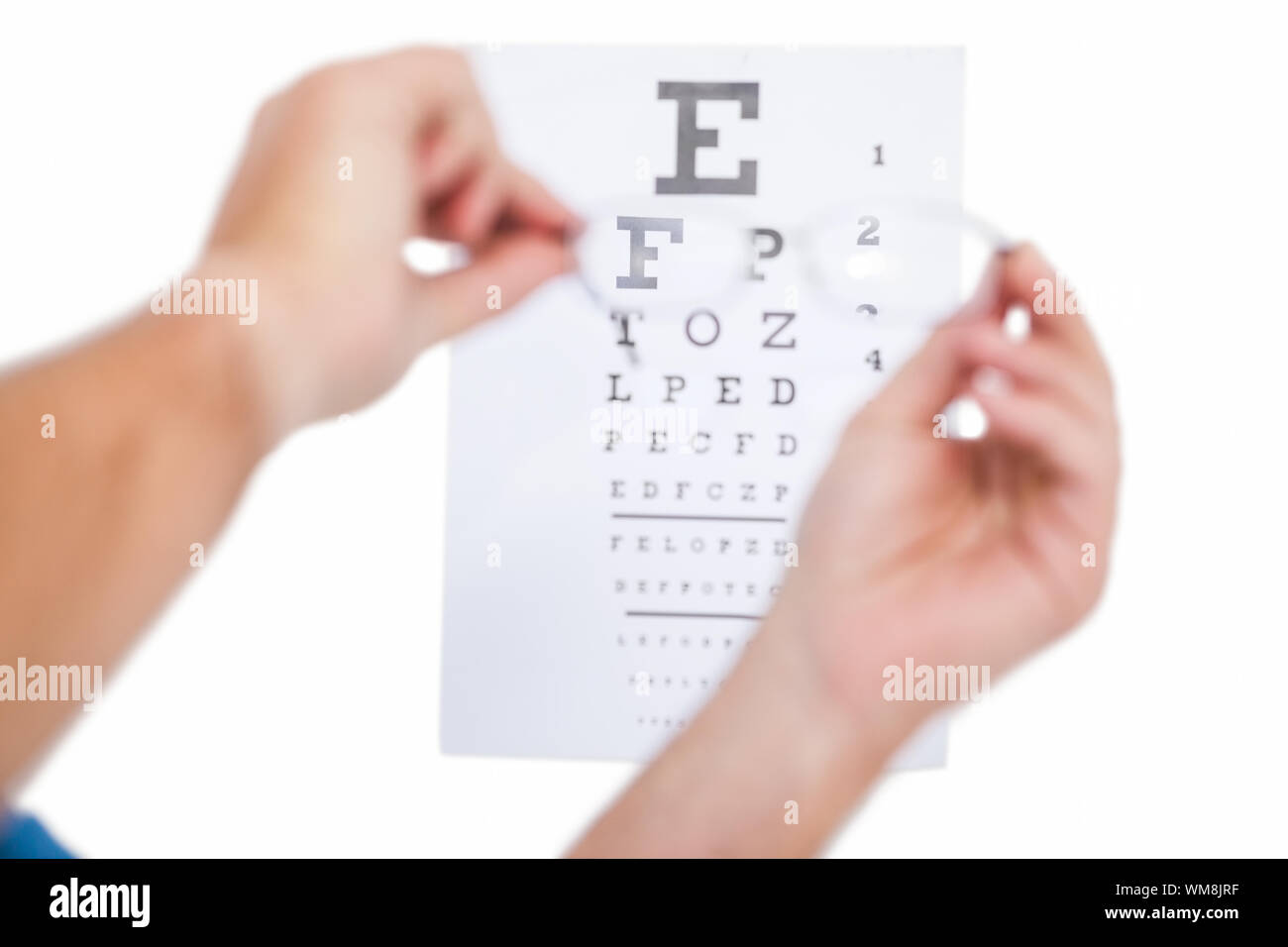 Hands holding glasses for eye test on white background Stock Photo - Alamy
