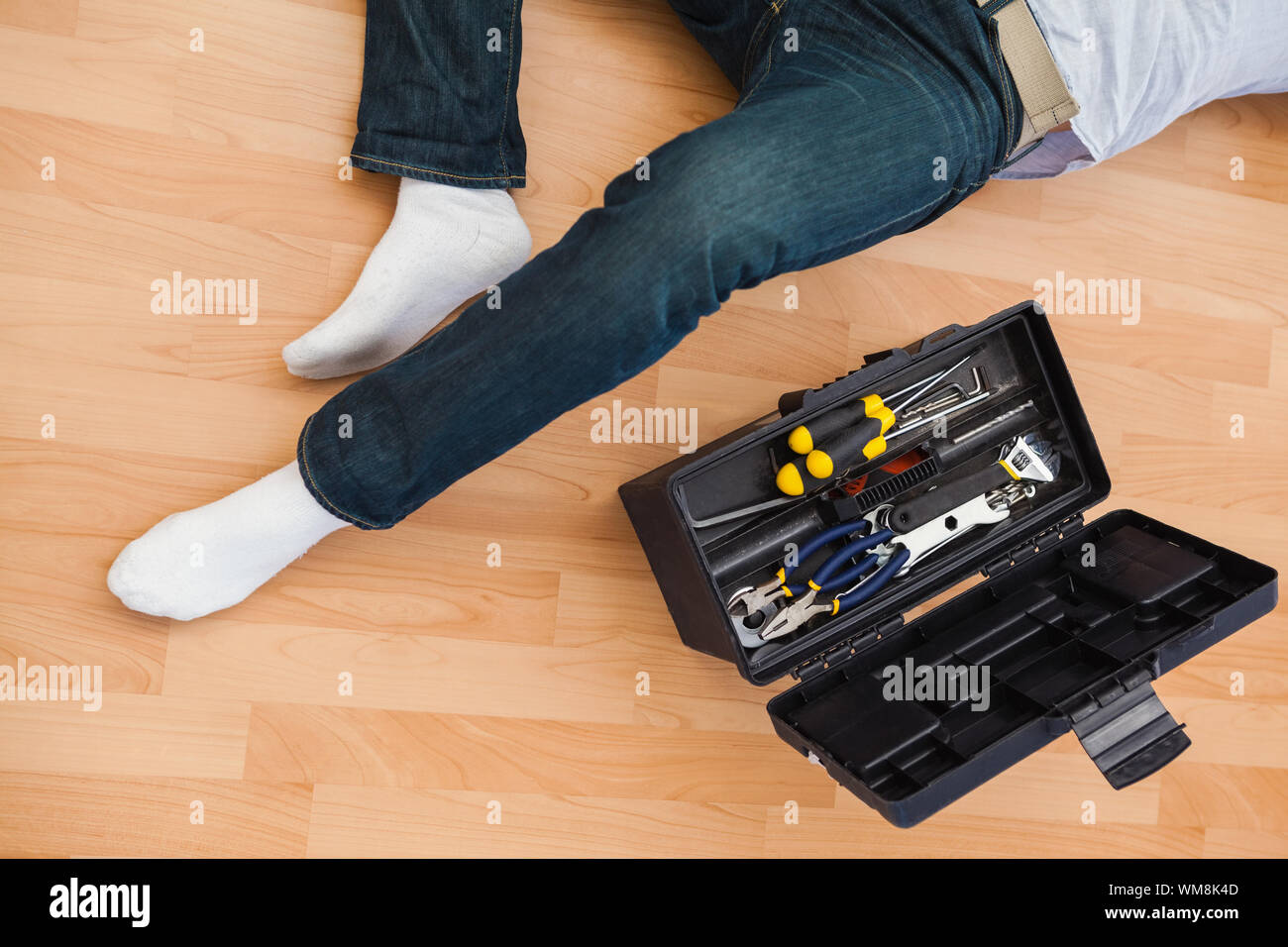 Mid section of a man lying with tools box at apartment Stock Photo - Alamy