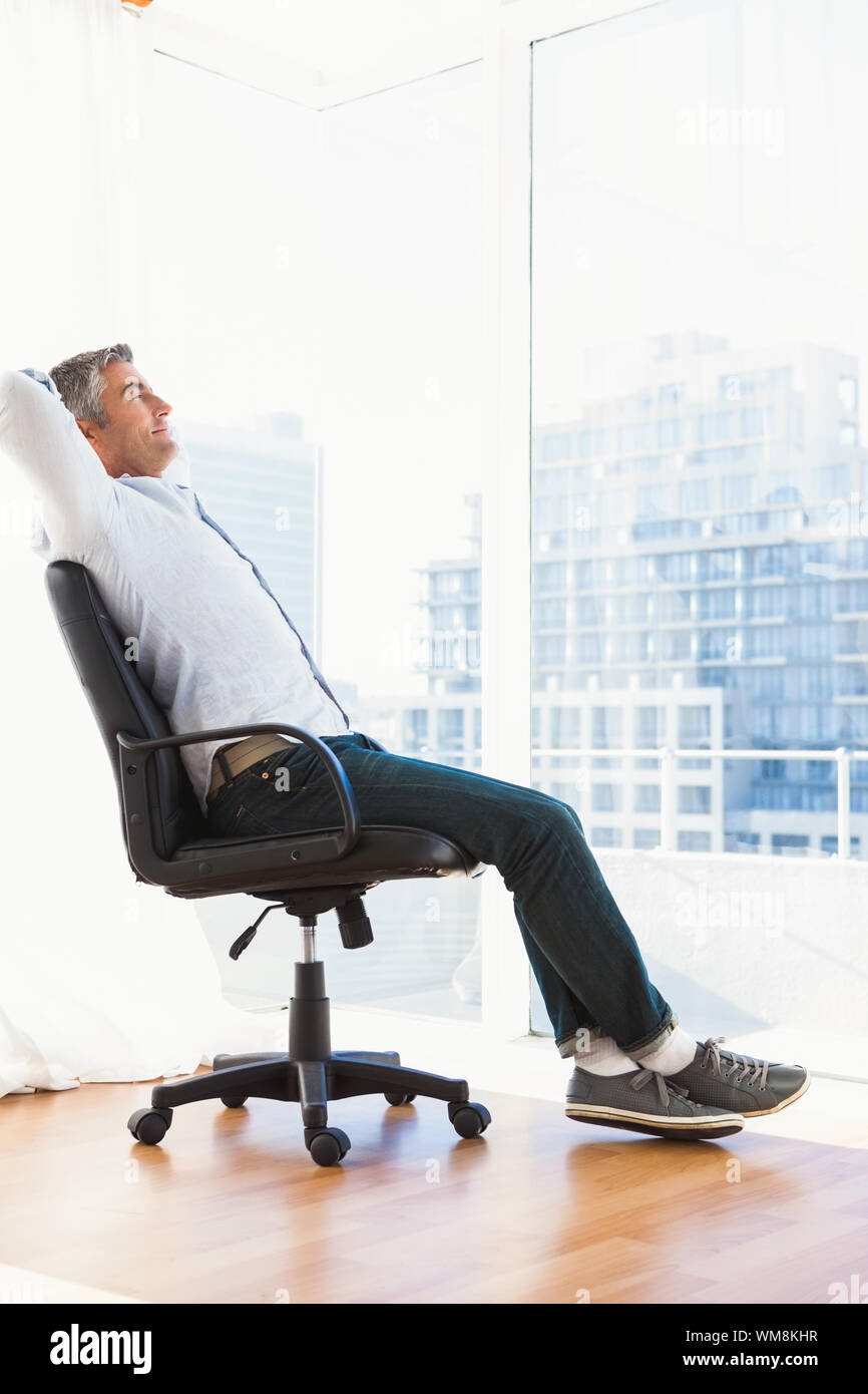 Man sitting on his office chair resting at apartment Stock Photo - Alamy