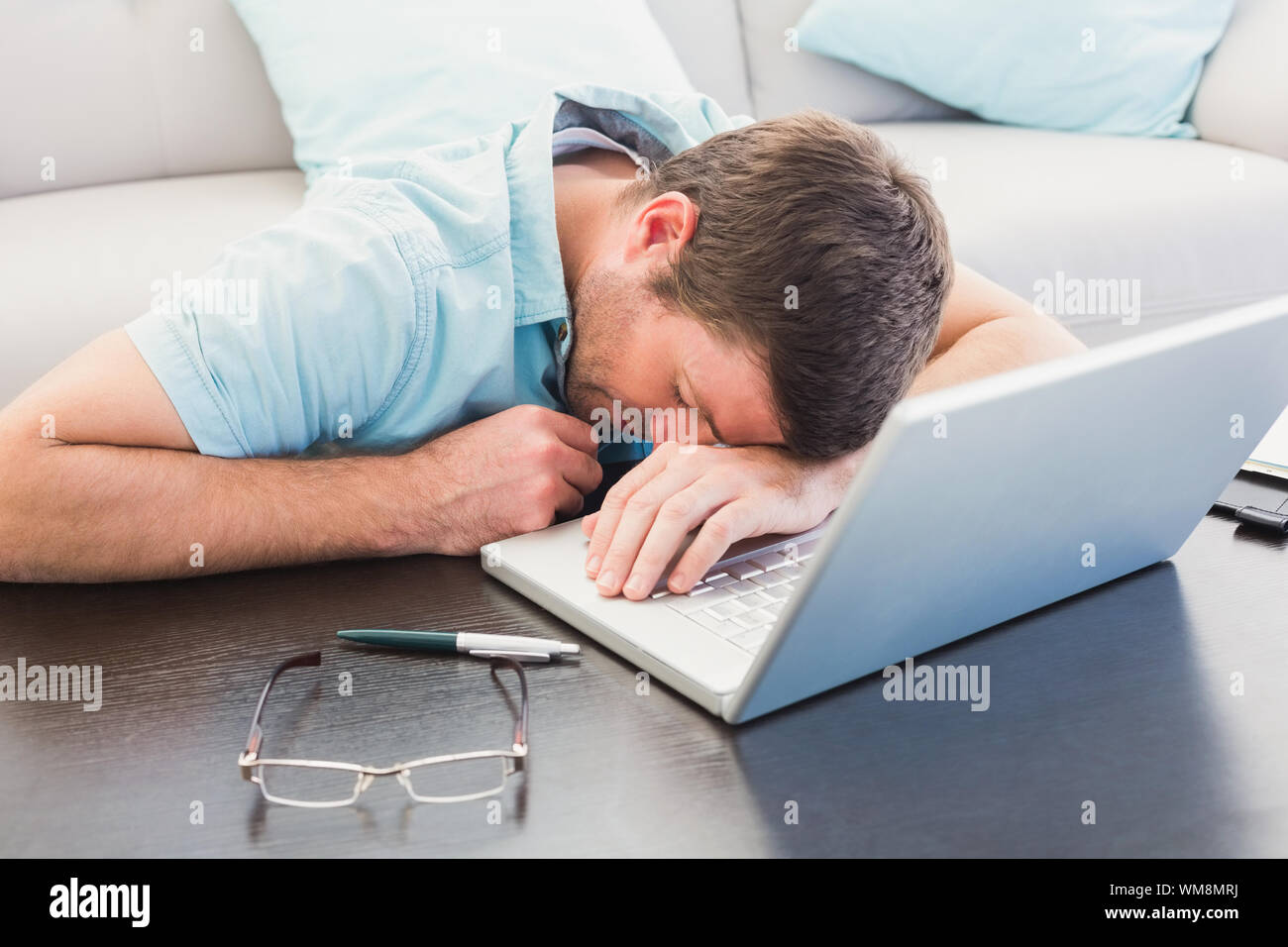 Man sleeping on a table in the living room Stock Photo - Alamy