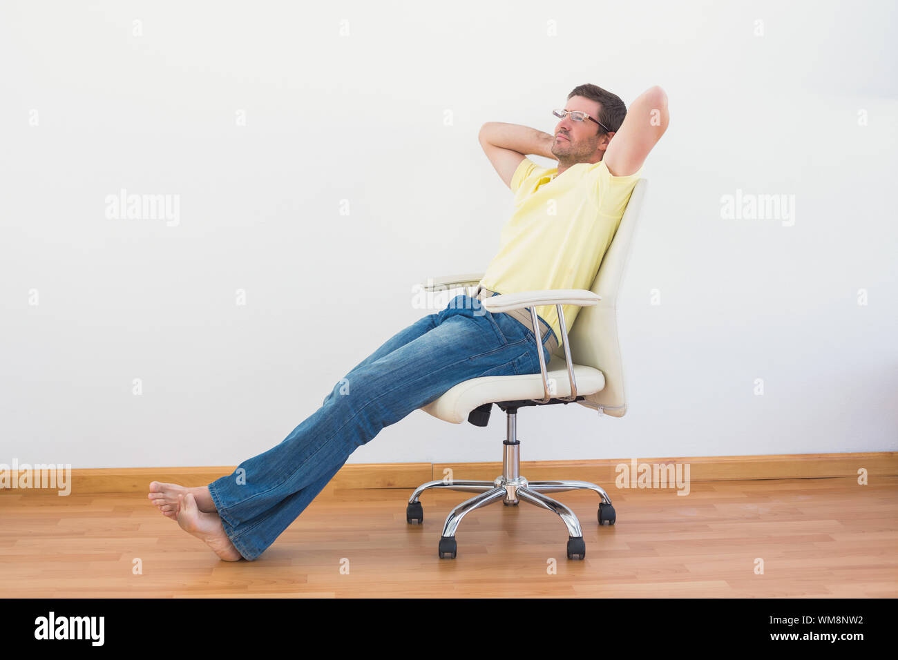 A man leaning back in swivel chair at home in the living room Stock ...