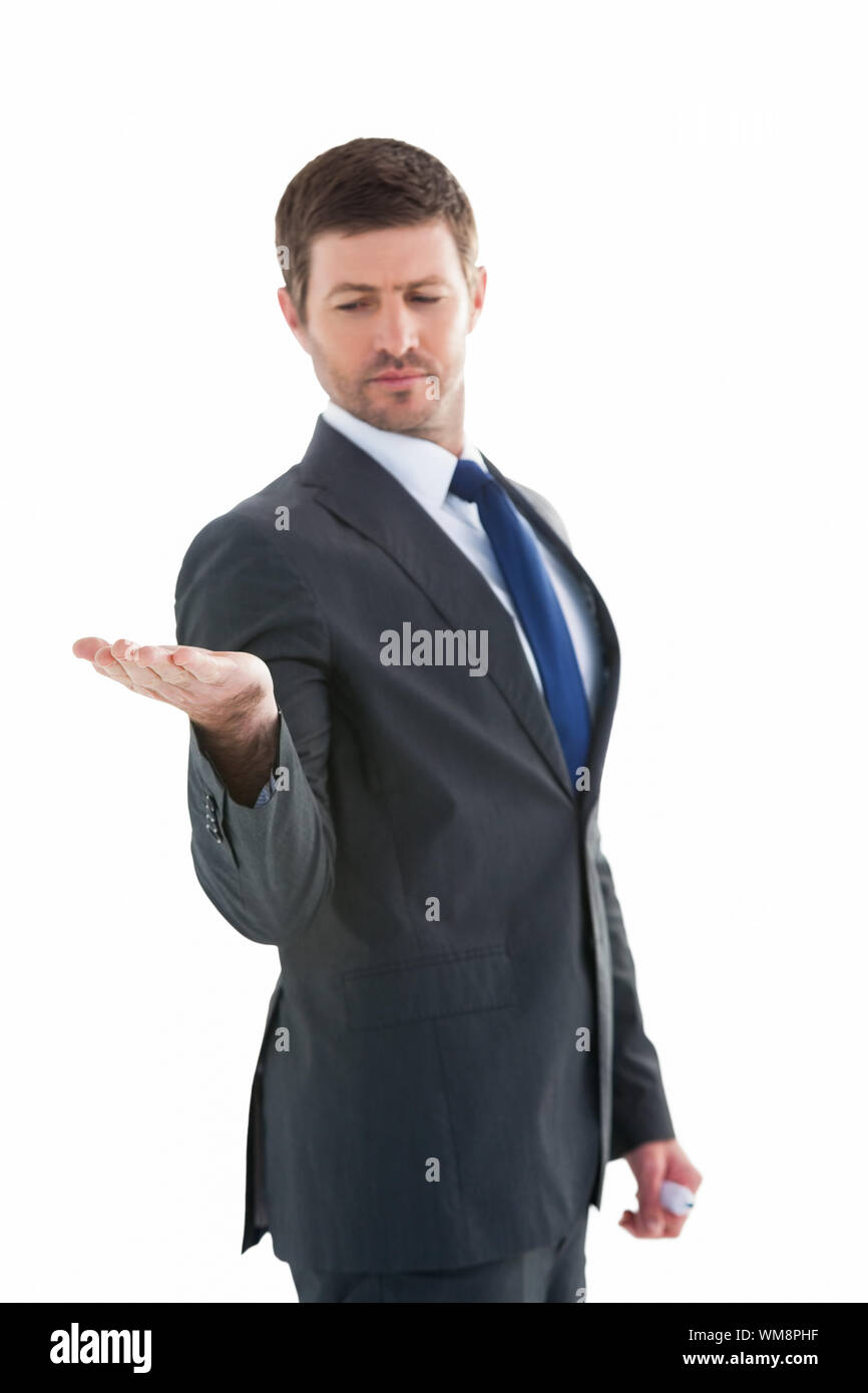 Businessman holding hand out in presentation on white background Stock ...