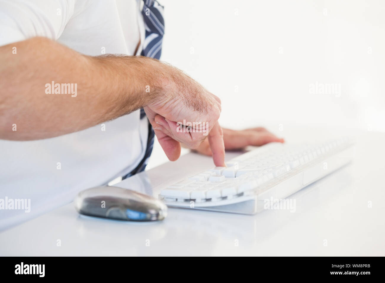 Mid section of businessman using computer keyboard on white background ...