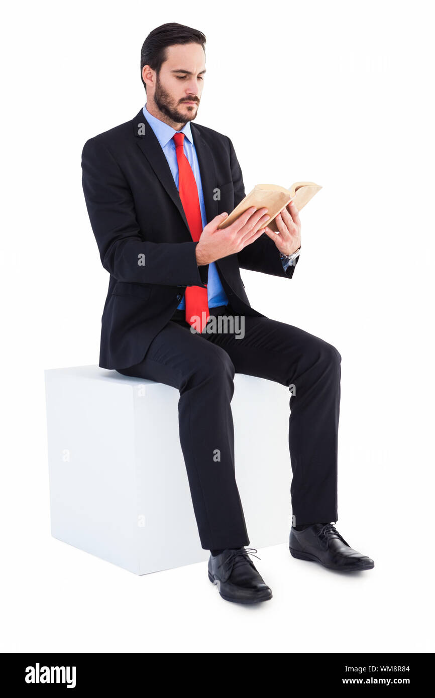 Thoughtful businessman sitting reading book on white background Stock ...