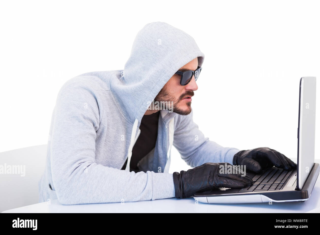 Serious burglar hacking into laptop on white background Stock Photo - Alamy
