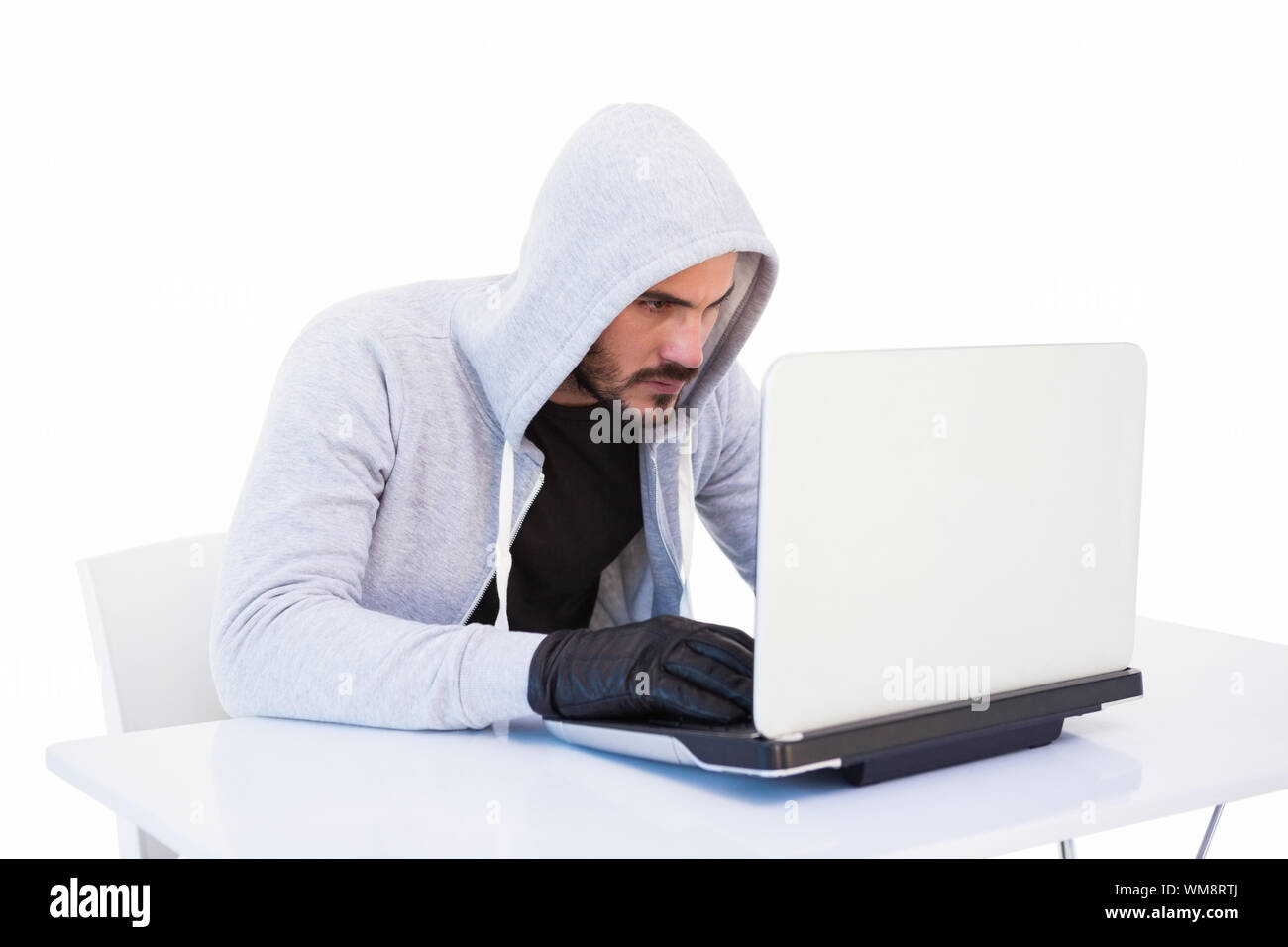 Serious burglar hacking into laptop on white background Stock Photo - Alamy