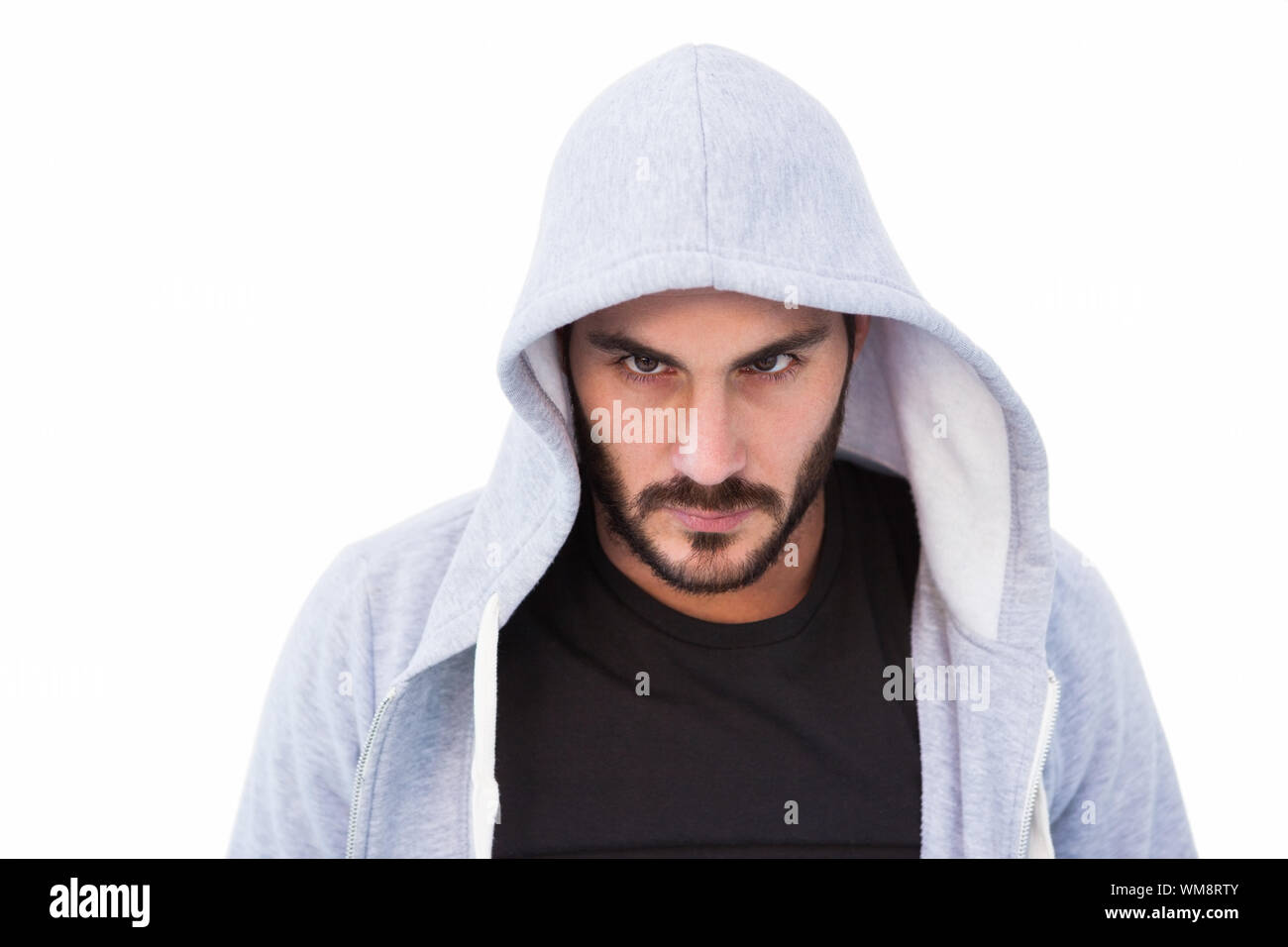 Portrait of dangerous man wearing hooded jacket on white background ...