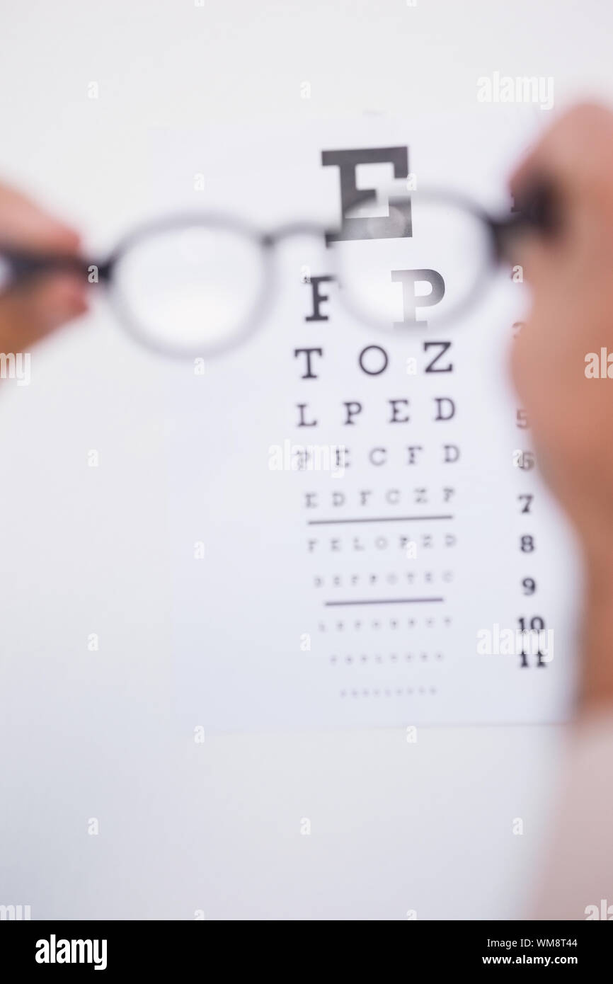 Reading glasses looking at eye test on white background Stock Photo - Alamy