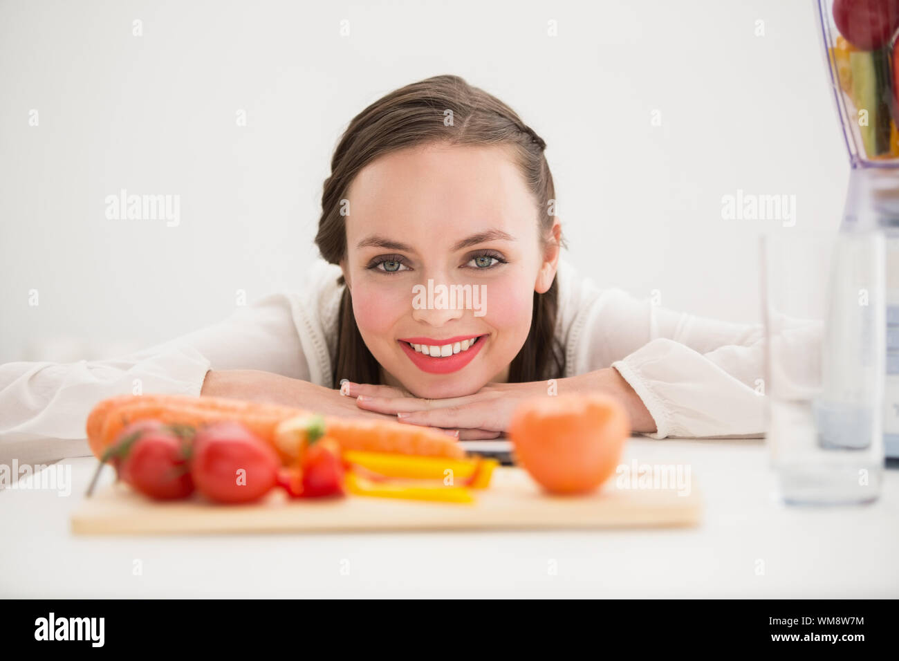 Pretty brunette preparing a healthy juice at home in the kitchen Stock ...