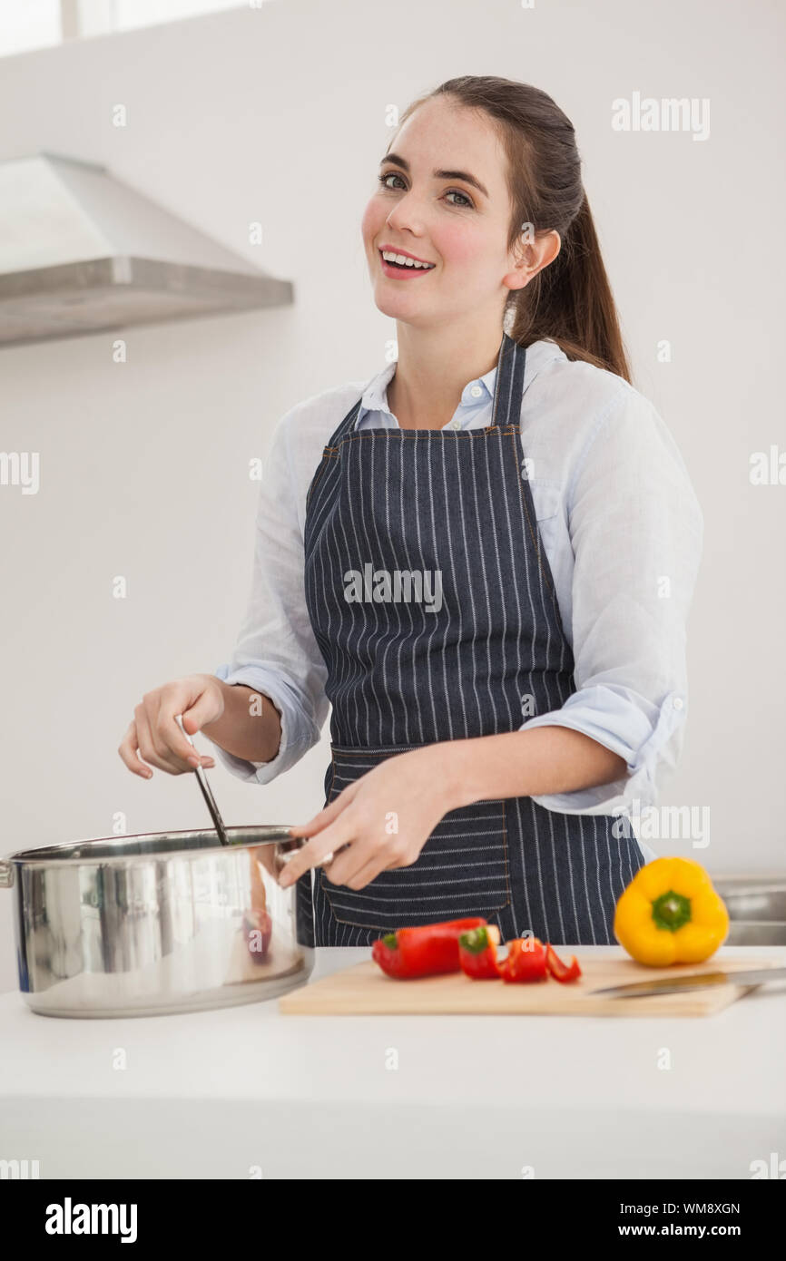Pretty brunette cooking a healthy meal at home in the kitchen Stock ...