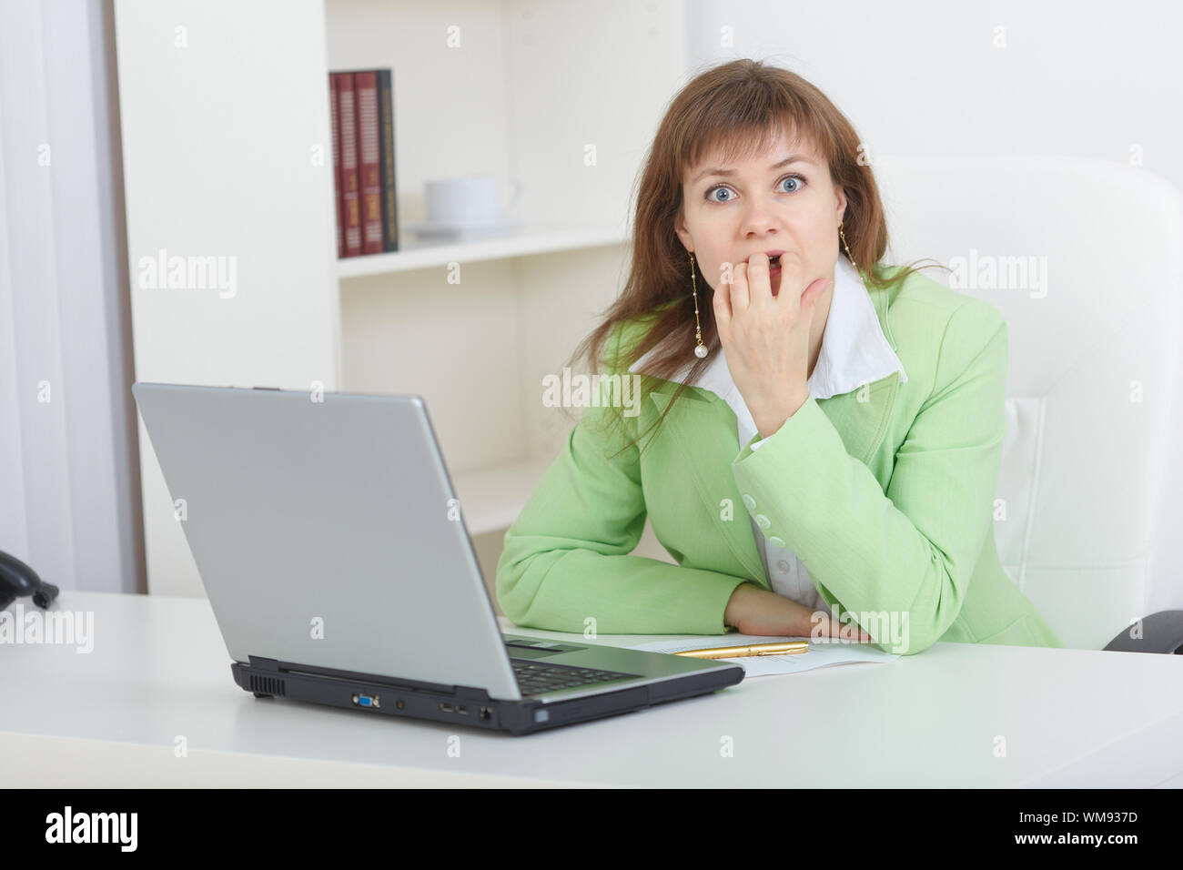 The scared woman sits on a workplace with the laptop Stock Photo - Alamy