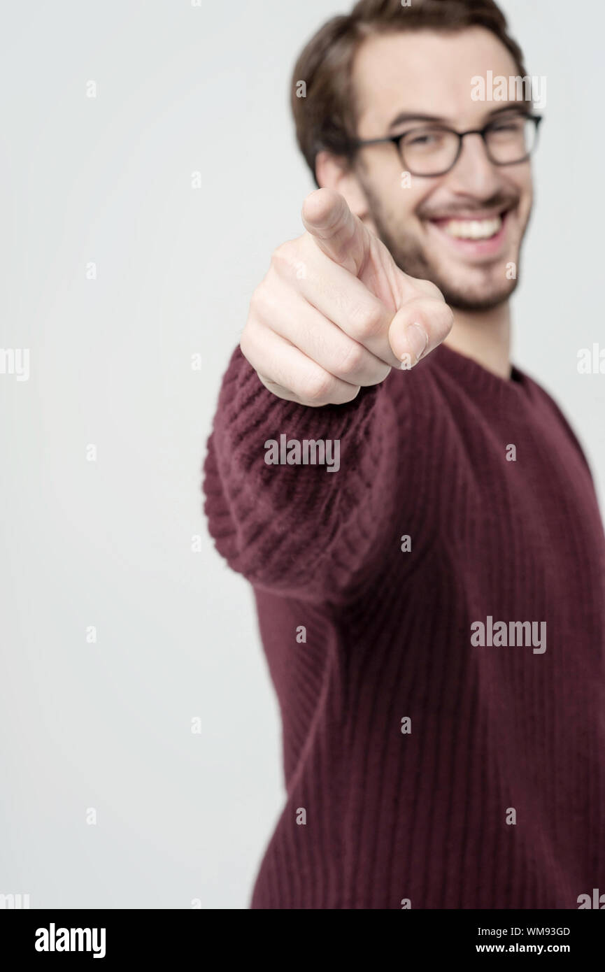 Cheerful young man pointing towards camera Stock Photo - Alamy