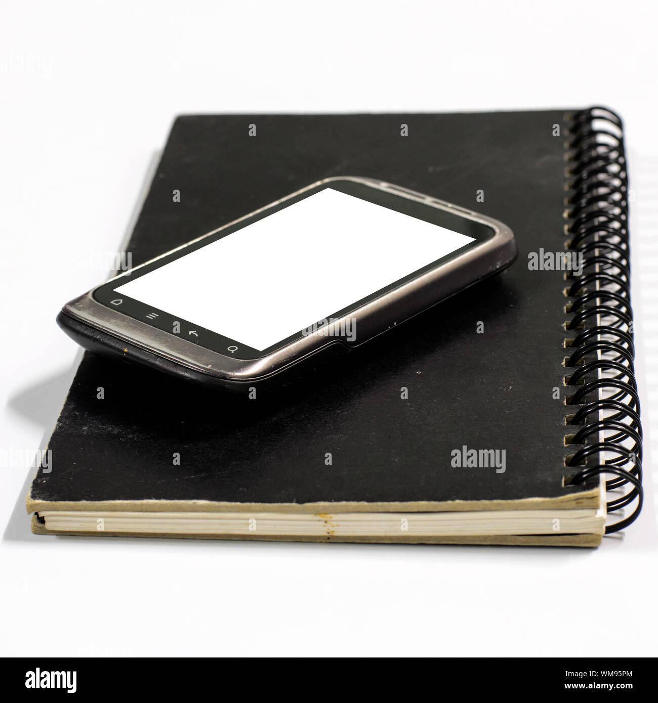 smartphone on note book on a white background Stock Photo - Alamy