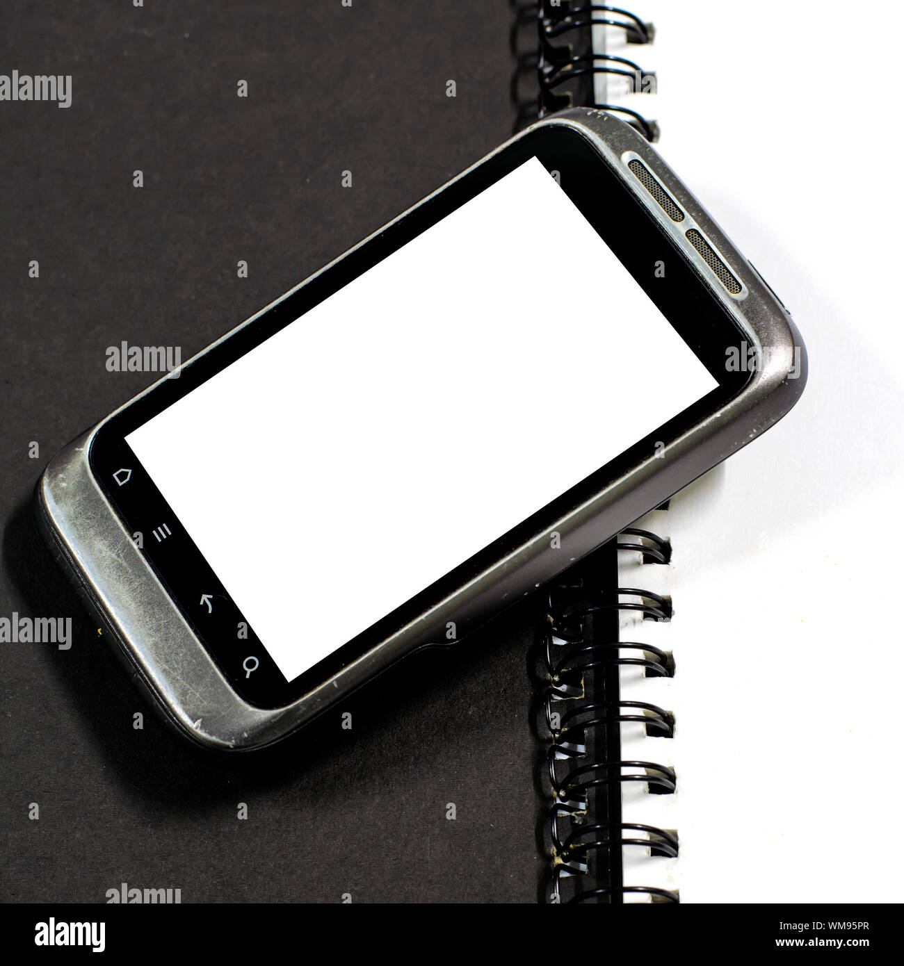 smartphone on note book on a white background Stock Photo - Alamy