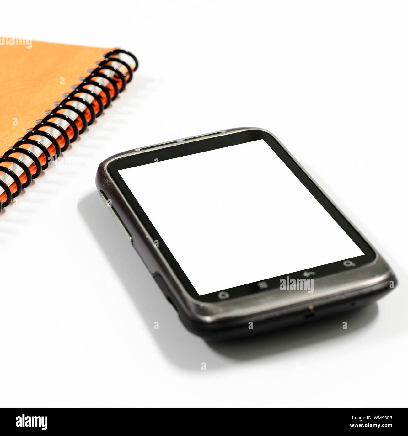 smartphone with orange note book on a white background Stock Photo - Alamy
