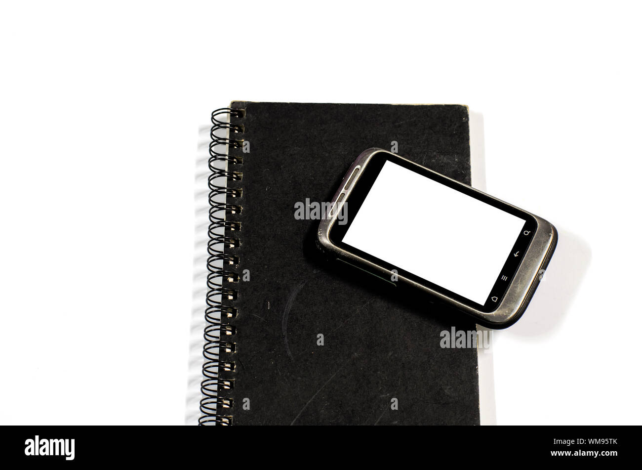 smartphone on note book on a white background Stock Photo - Alamy