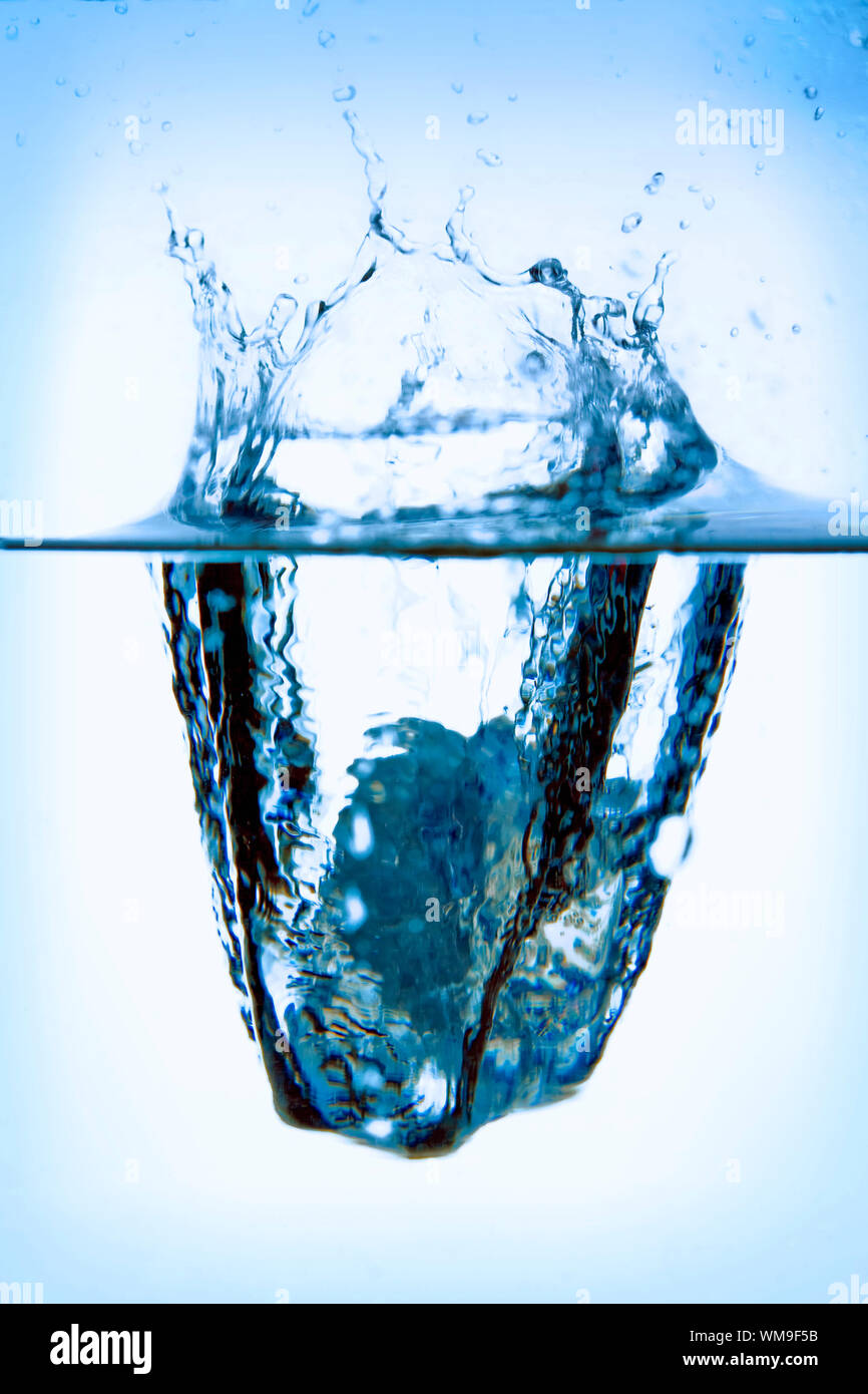 ice cube falling into water making waves and splashes Stock Photo - Alamy