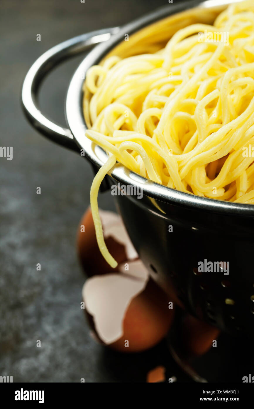 spaghetti in colander on dark vintage background Stock Photo - Alamy