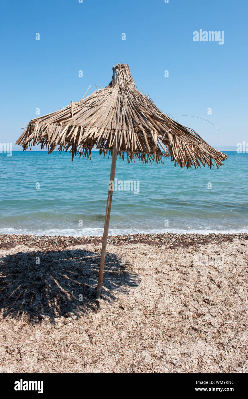 Beach with straw parasol at the coast Stock Photo - Alamy