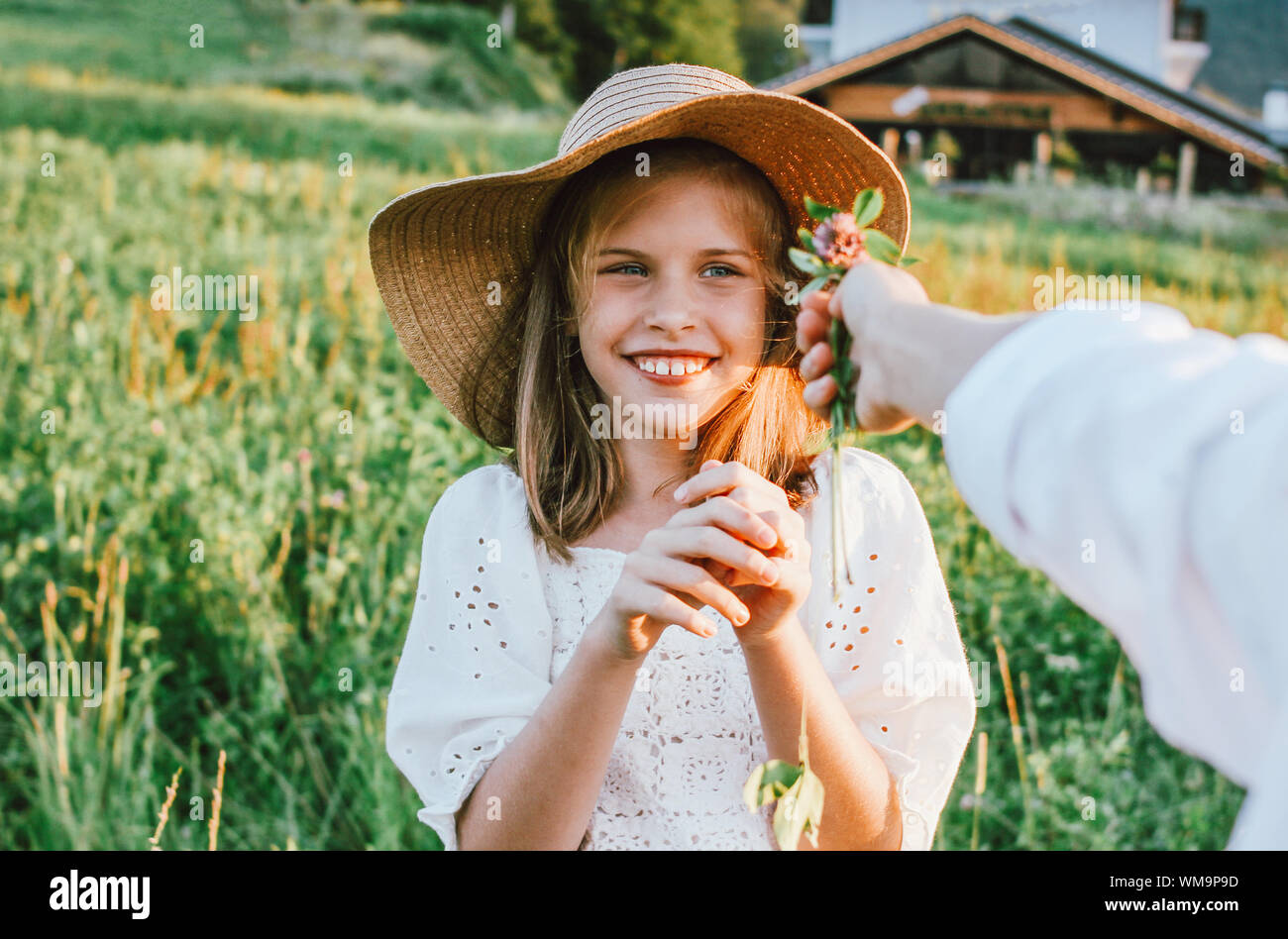 Laughing children friends at green meadow, rural scene. Boy gives ...
