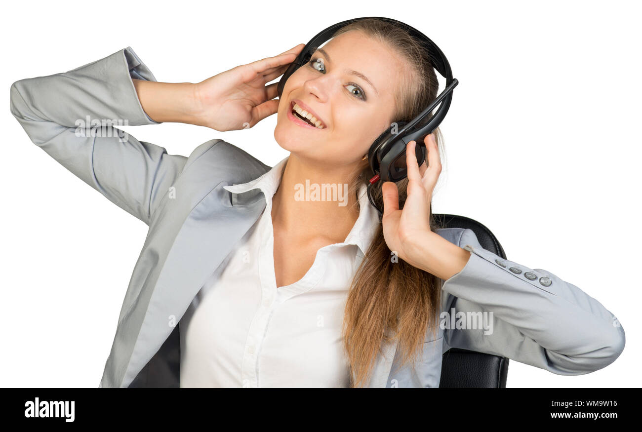 Businesswoman in headset with her hands on speakers, her had tilted ...