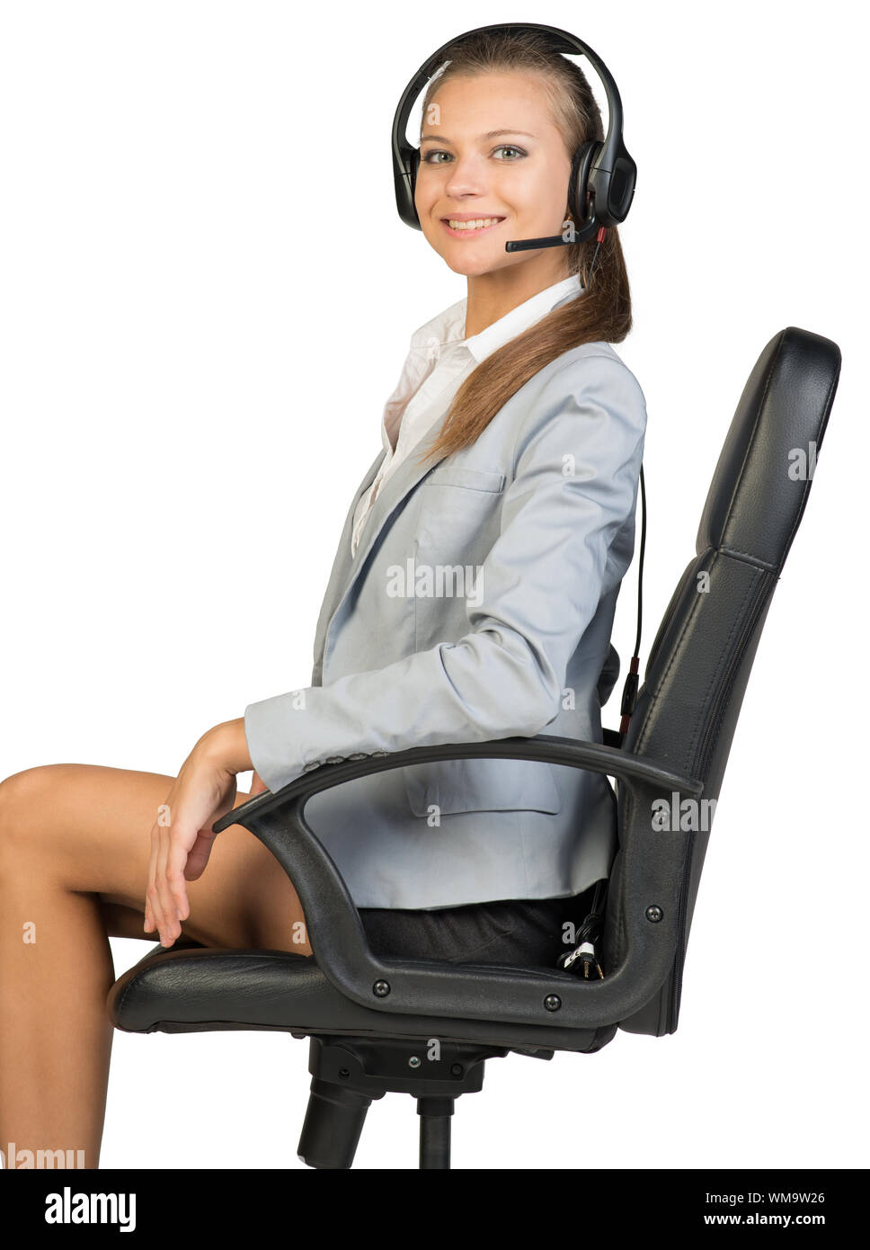 Businesswoman in headset with her head half-turned to camera, looking ...