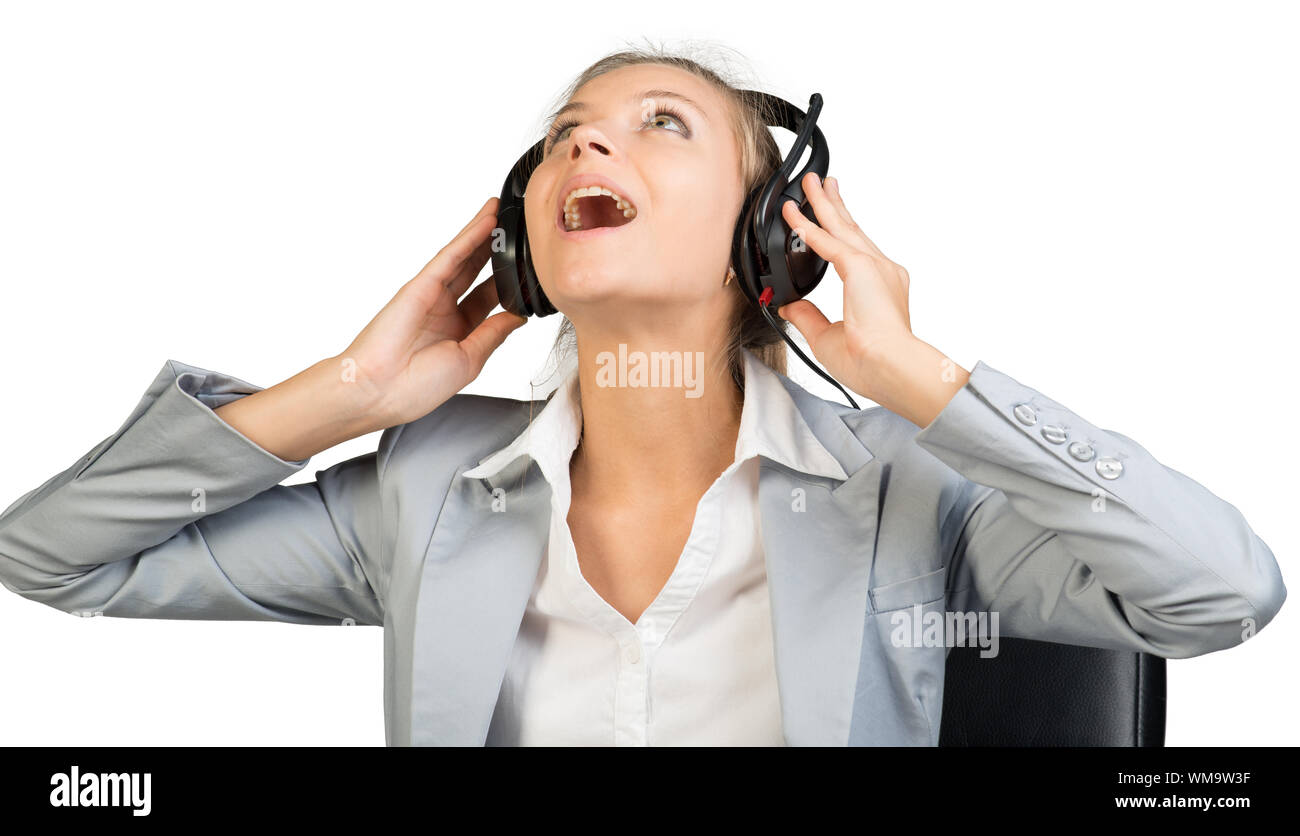 Businesswoman in headset with her hands on headset speakers, looking ...