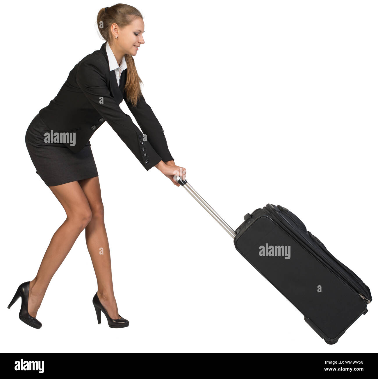 Businesswoman dragging heavy wheeled suitcase at utmost strain ...