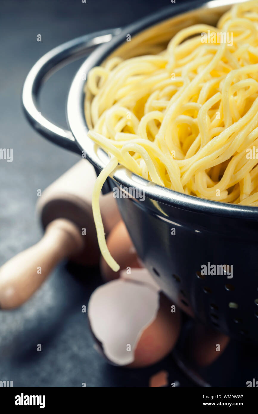 spaghetti in colander on dark vintage background Stock Photo - Alamy