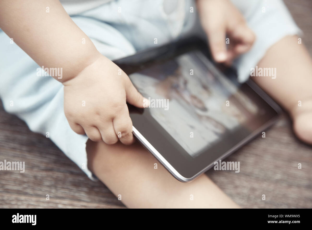 Baby with tablet computer. Close-up photo of the hands Stock Photo - Alamy