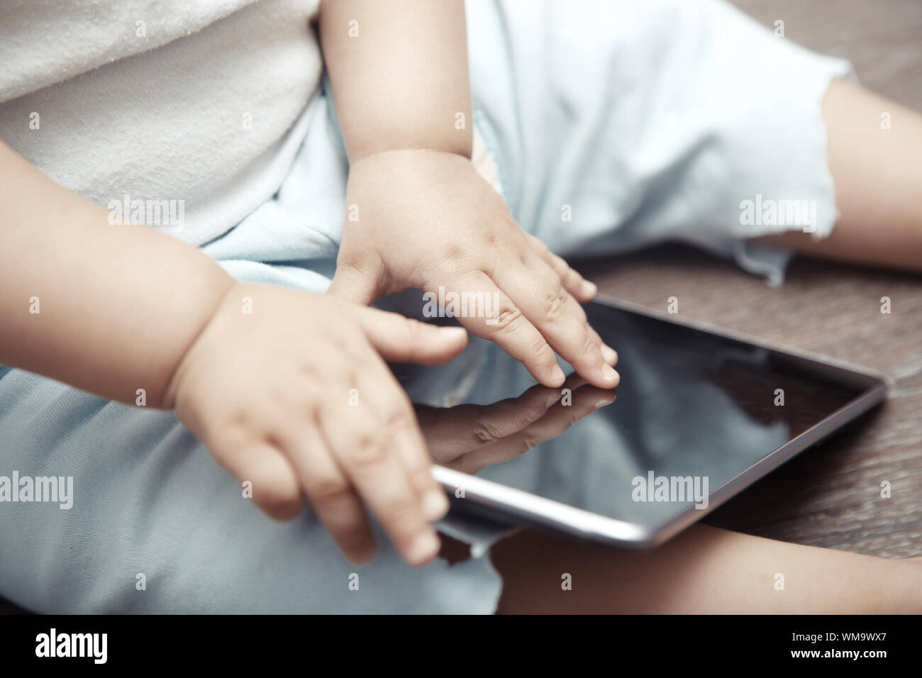 Baby with tablet computer. Close-up photo of the hands Stock Photo - Alamy