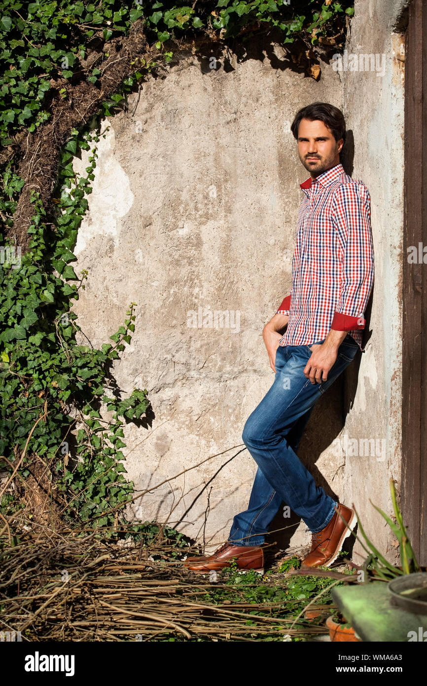 Smiling male model sitting on wooden crate with legs crossed Stock ...