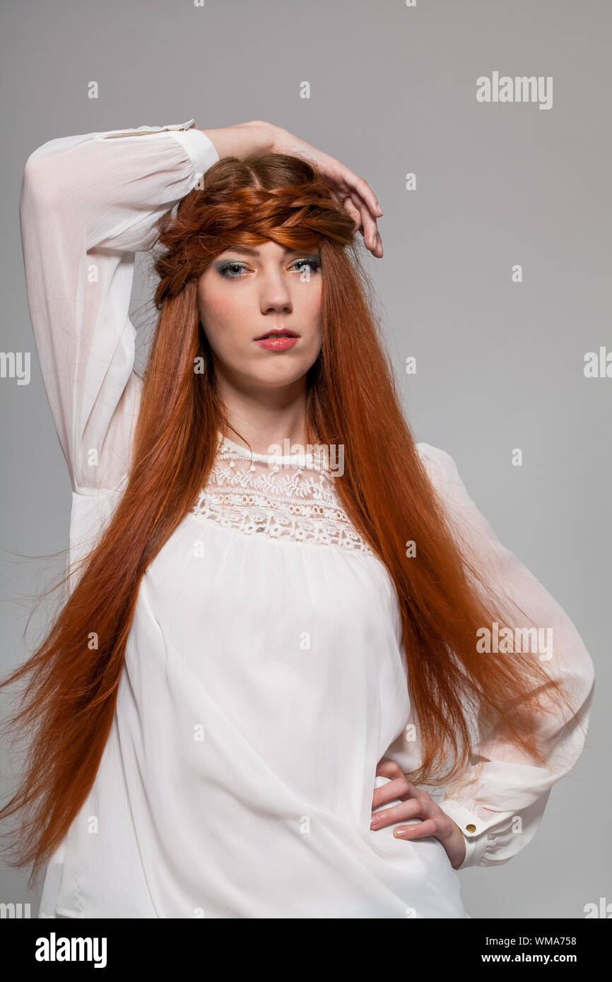 Pretty female model with serious look posing with hand on waist on ...