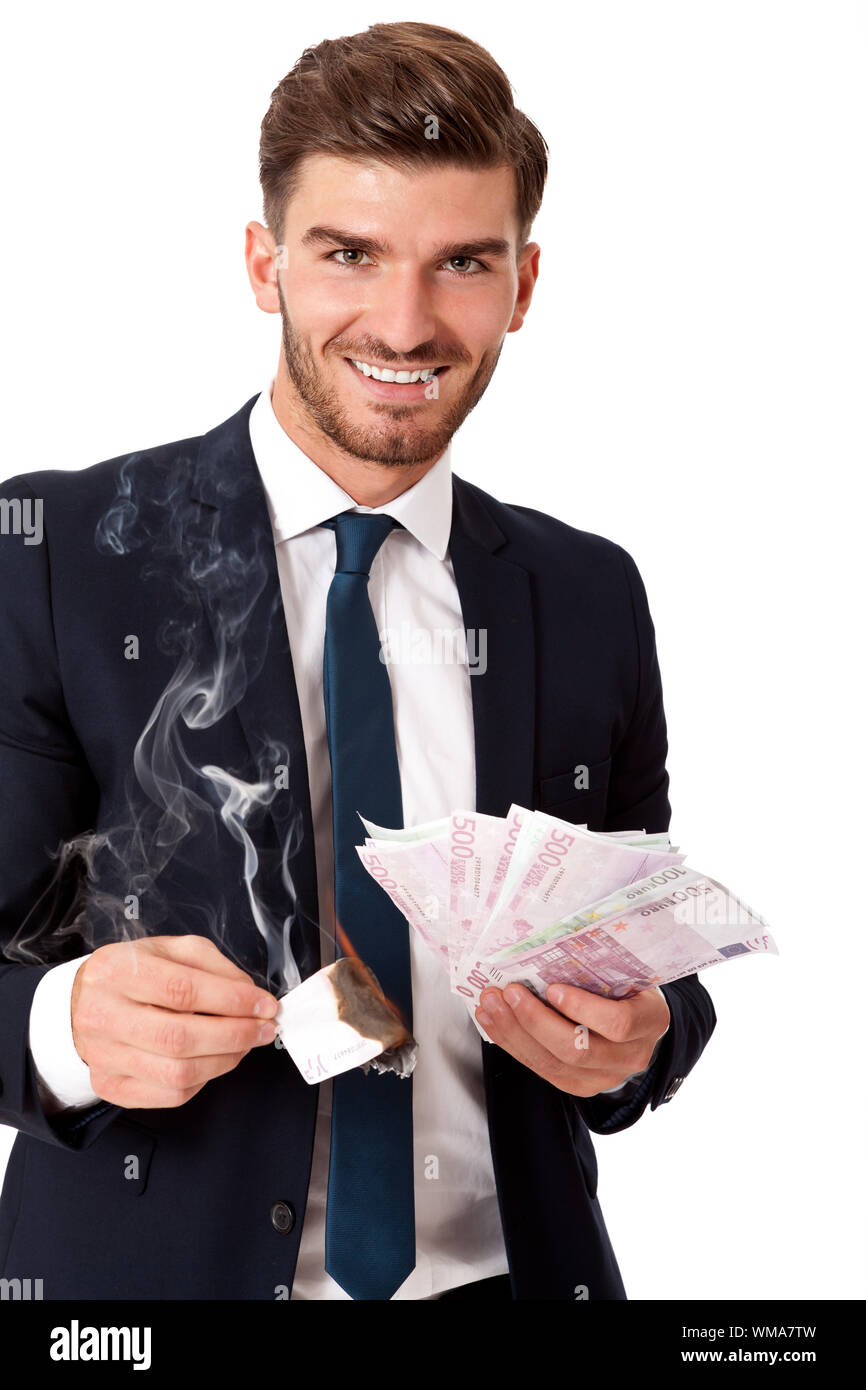 Wealthy successful stylish young businessman burning money from a ...