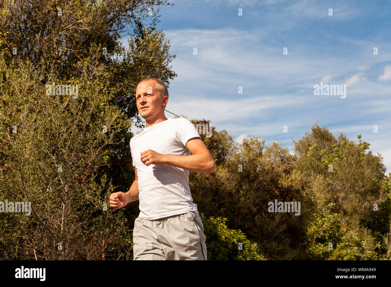 athletic man runner jogging in nature outdoor Stock Photo - Alamy