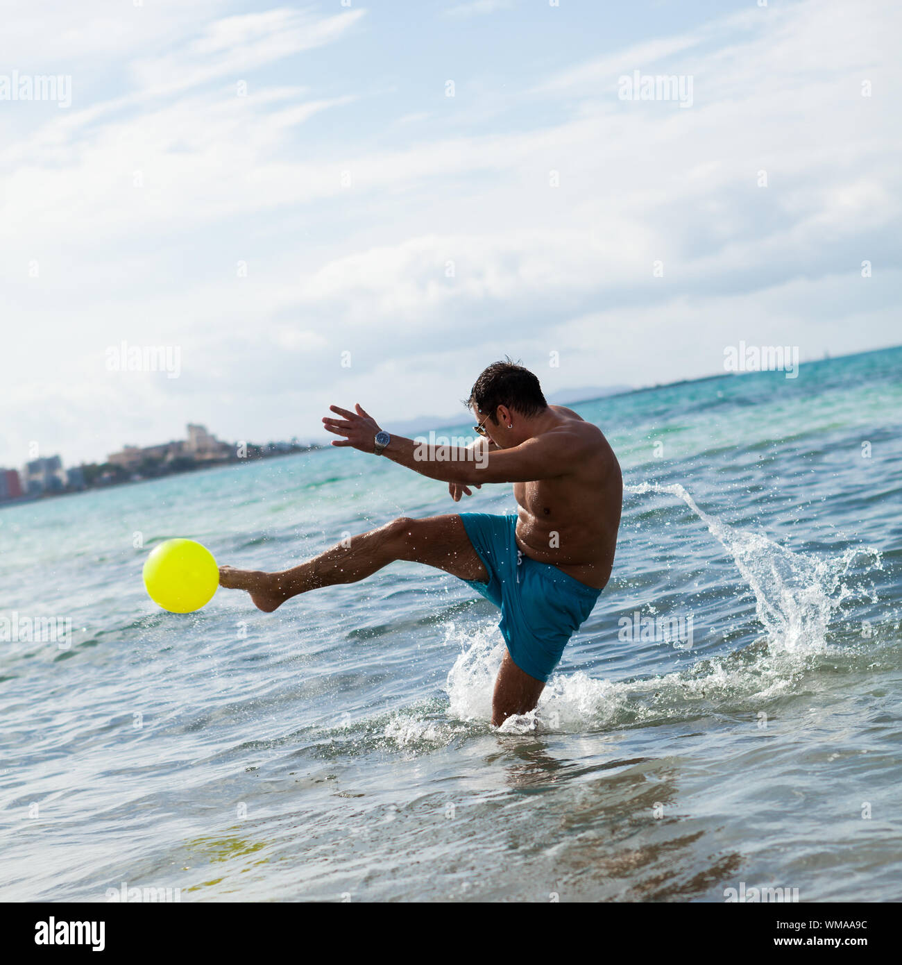 happy young adult man playing beach ball in summer Stock Photo - Alamy
