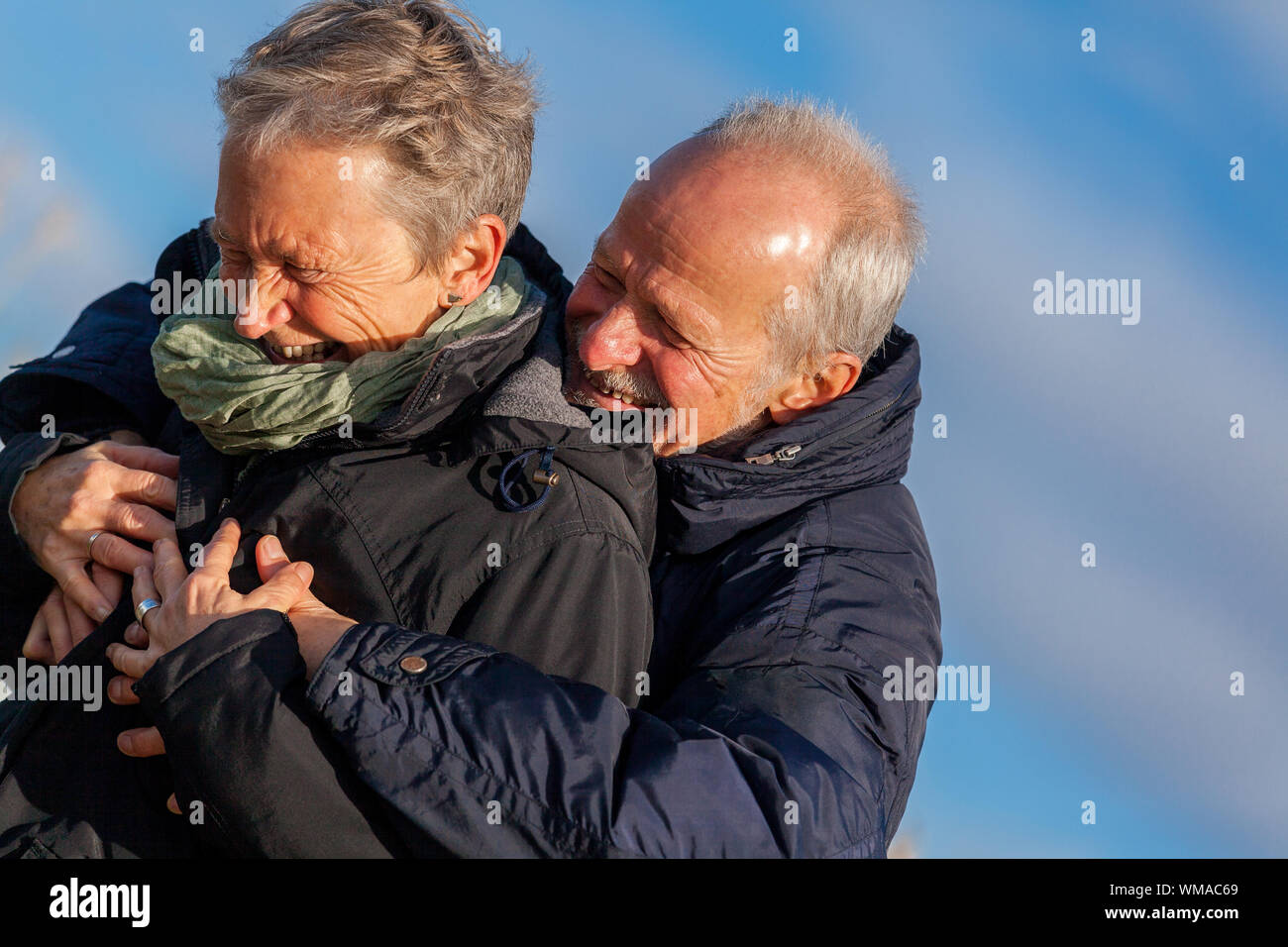 Elderly couple embracing and celebrating the sun Stock Photo - Alamy