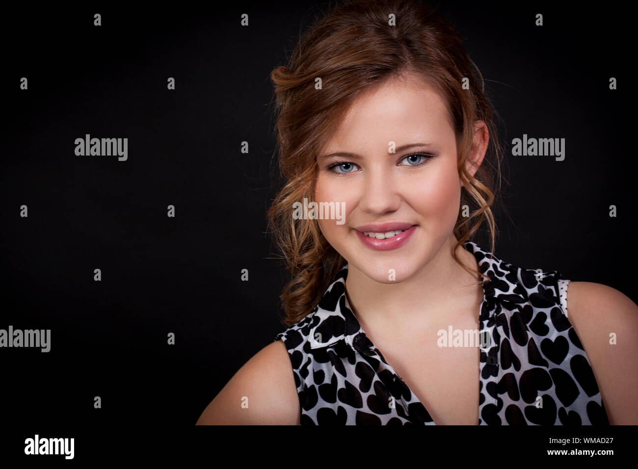 Beautiful young woman with a sincere smile and gentle expression ...