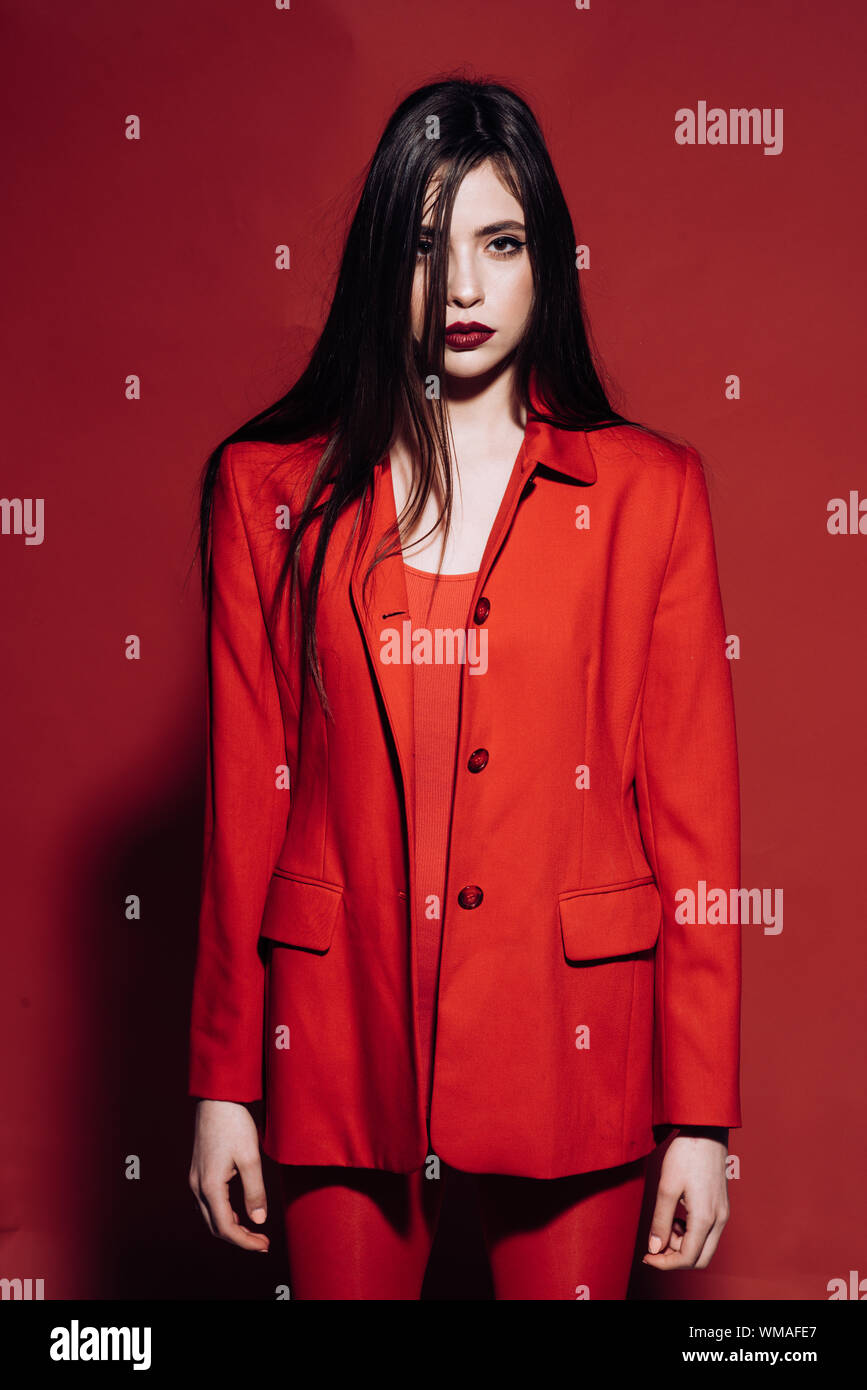 Woman with stylish makeup and long hair posing in total red outfit ...